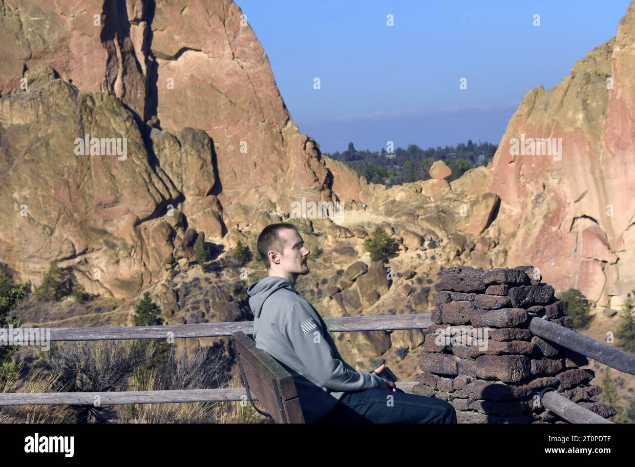 Young man rests on park bench in Smith Rock State Park, in Oregon ...