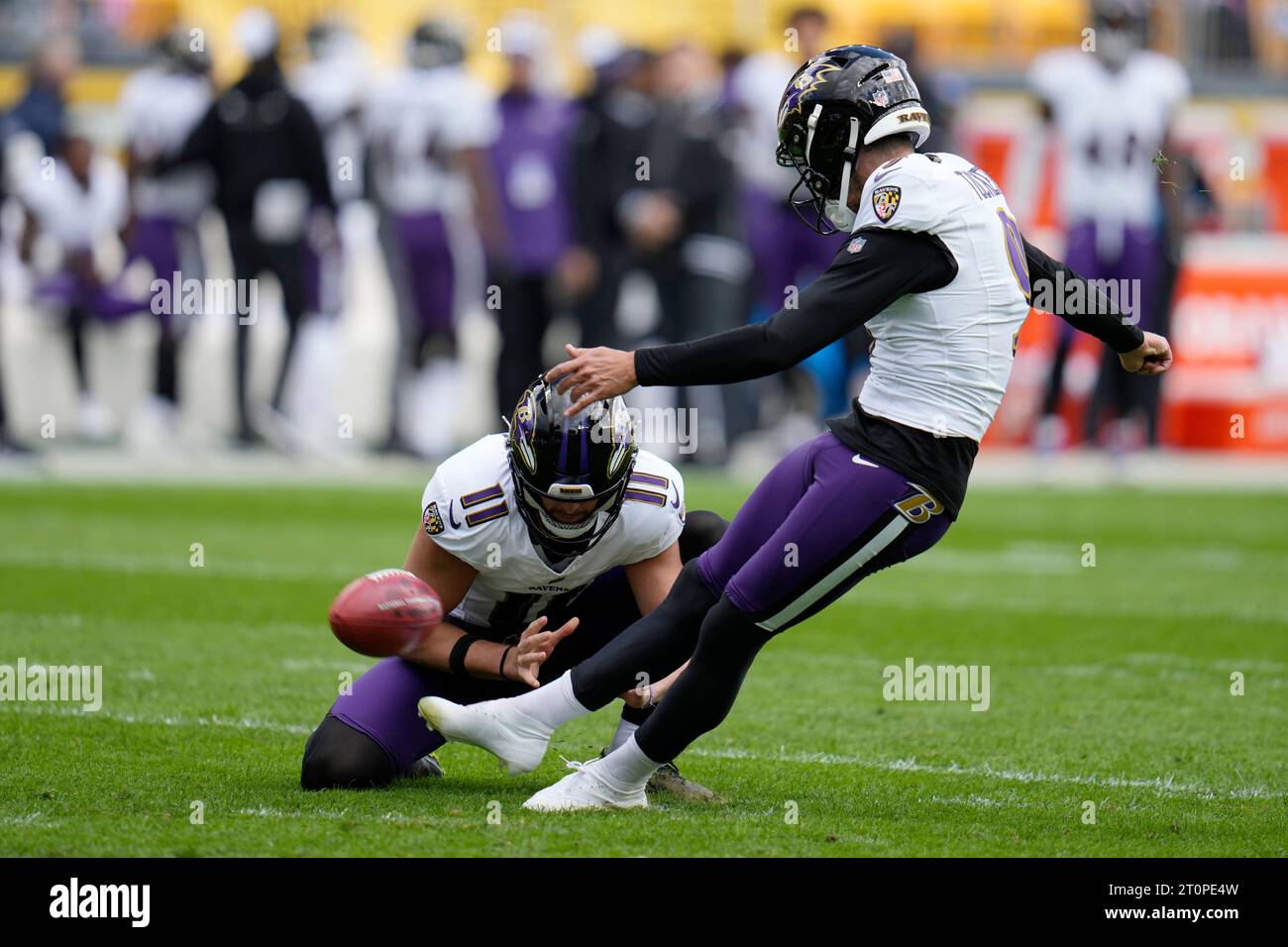 Baltimore Ravens' Jordan Stout (11) holds as Justin Tucker (9) kicks a ...