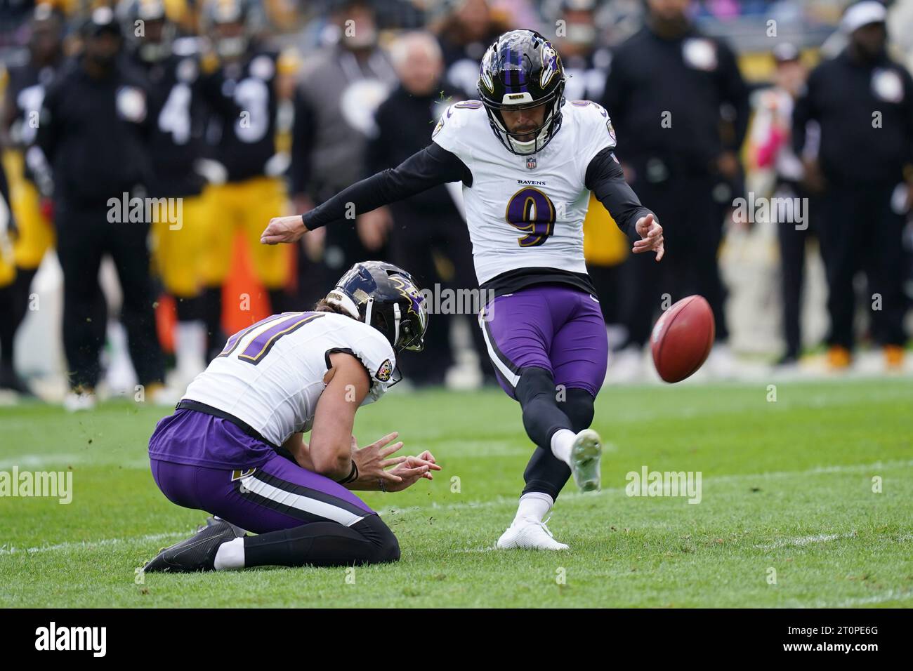 Baltimore Ravens' Jordan Stout (11) holds as Justin Tucker (9) kicks a ...