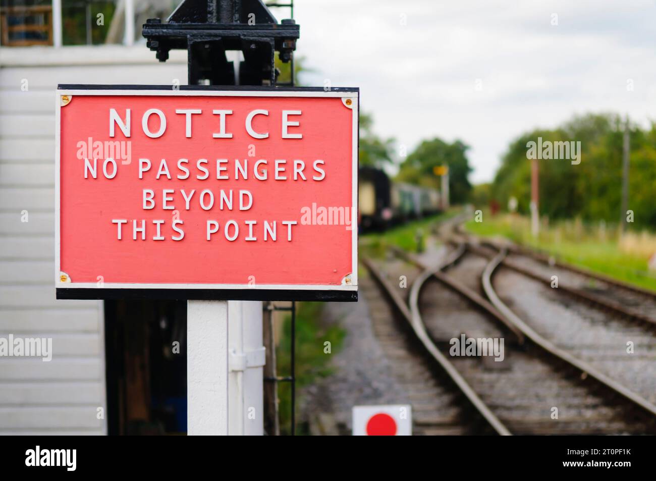 Sign by a railway track warning passengers not to go beyond Stock Photo ...