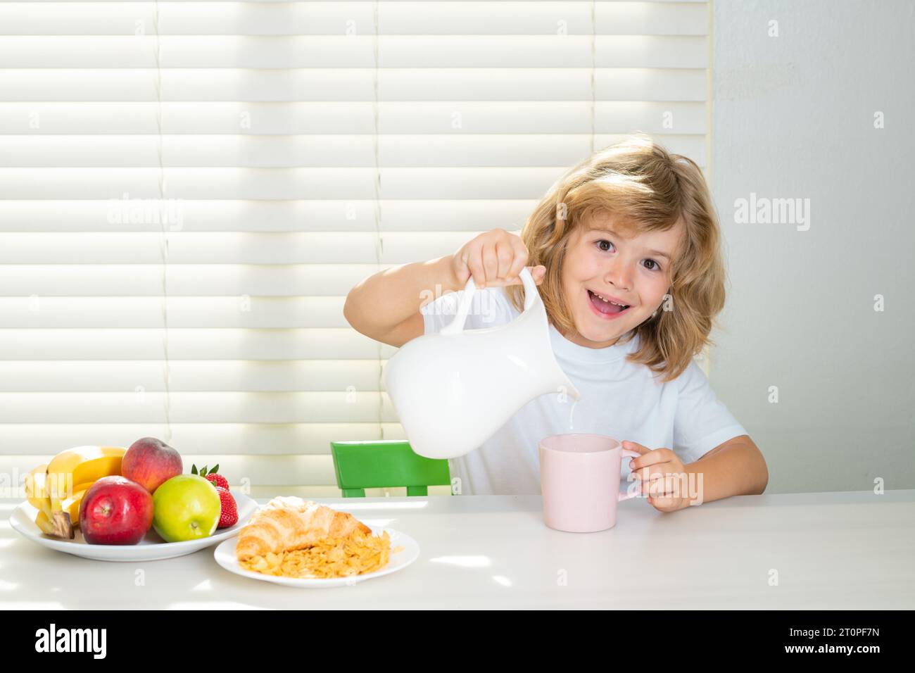 Fuuny little boy pouring whole cows milk for breakfast. Kid boy eating ...