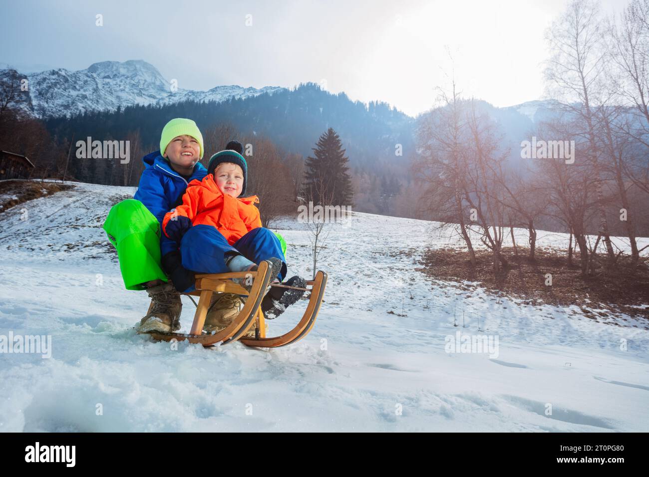 Two boys going downhill on wooded sledge together having fun Stock ...