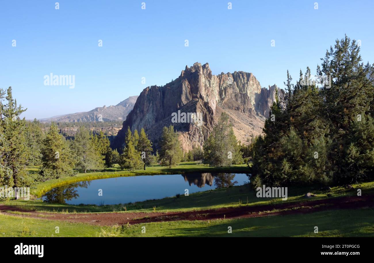 Rugged Cascade Mountain is reflected in a small pond in Oregon. Sky is ...