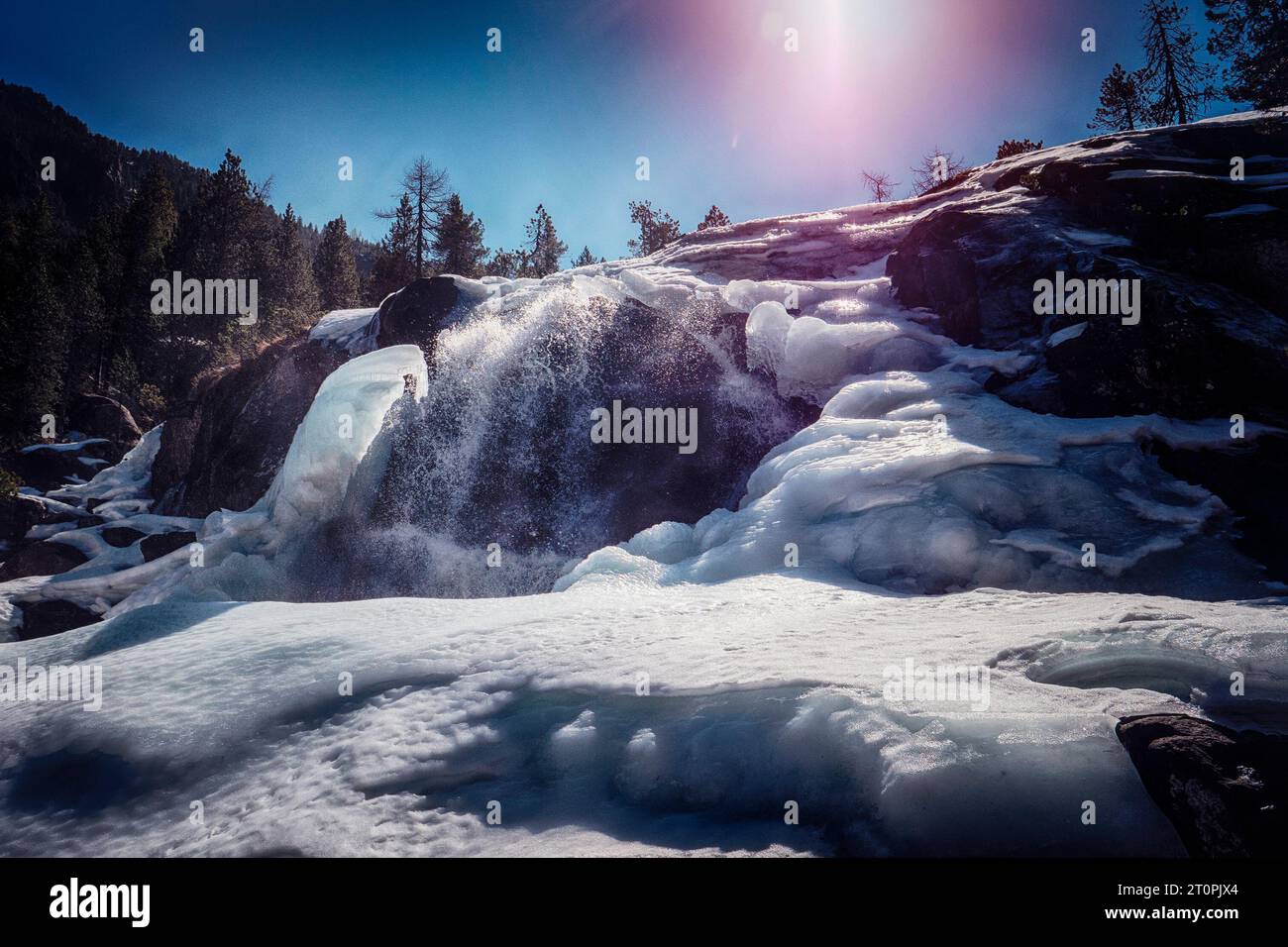 A waterfall in the middle of a snowy forest Stock Photo - Alamy