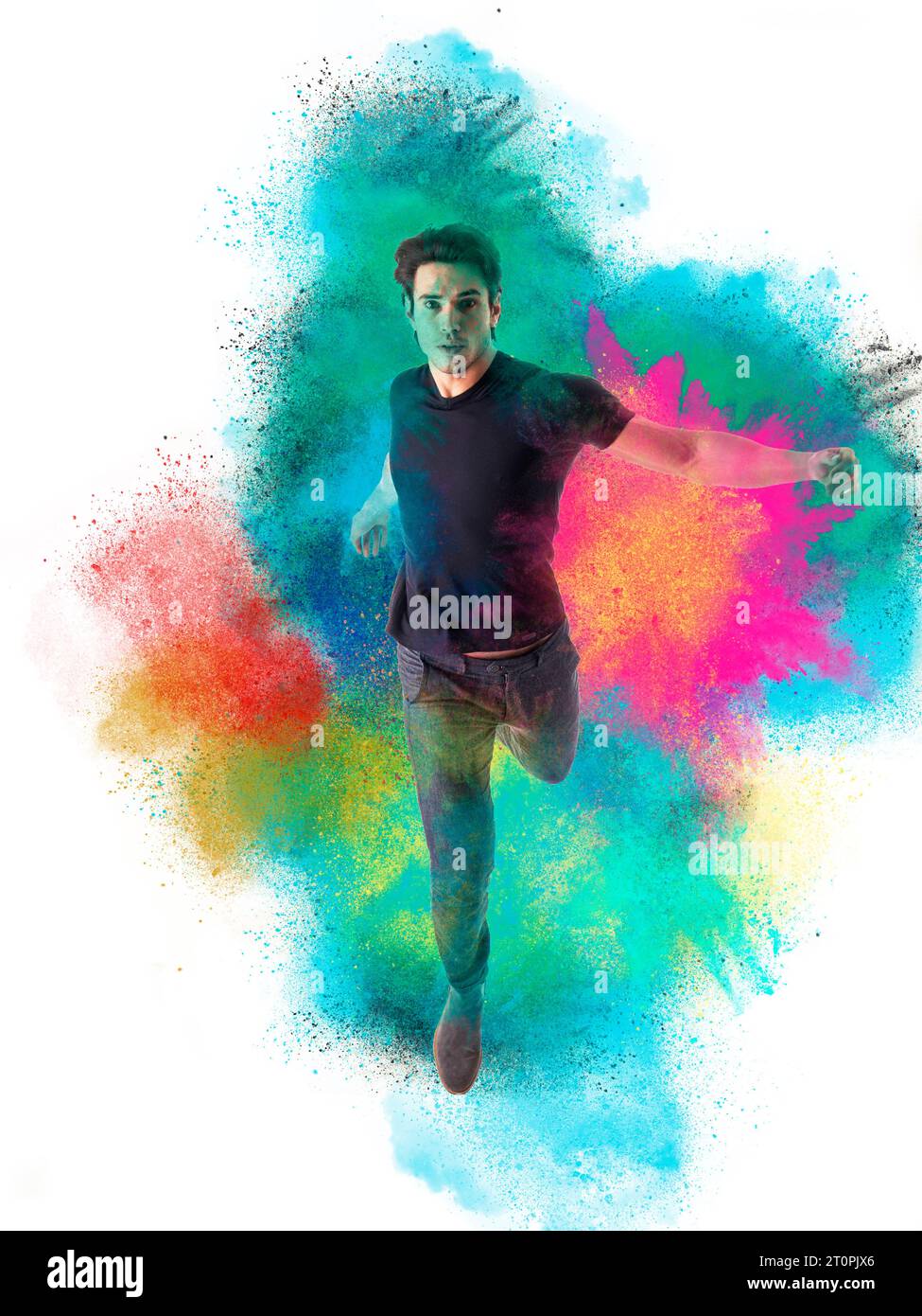 A man in a black shirt is running through colored powder. Photo of a ...