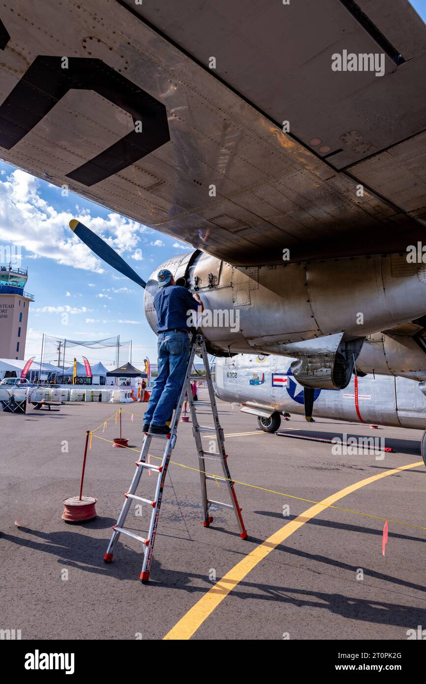 Man on a ladder does maintenance on an old airplane Stock Photo - Alamy