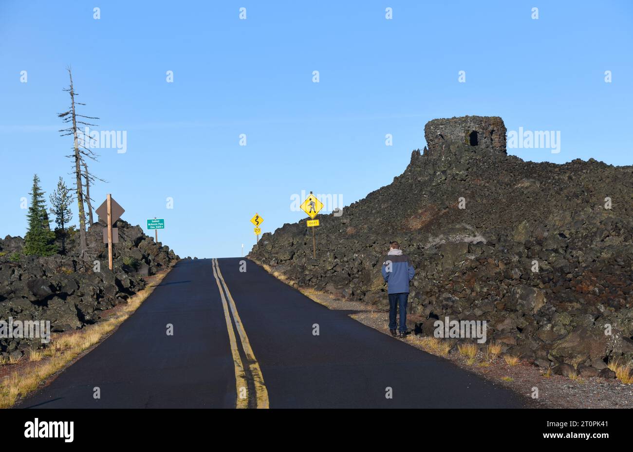 Male visitor hikes the McKenzie Pass in Central Oregon. Dee Wright ...