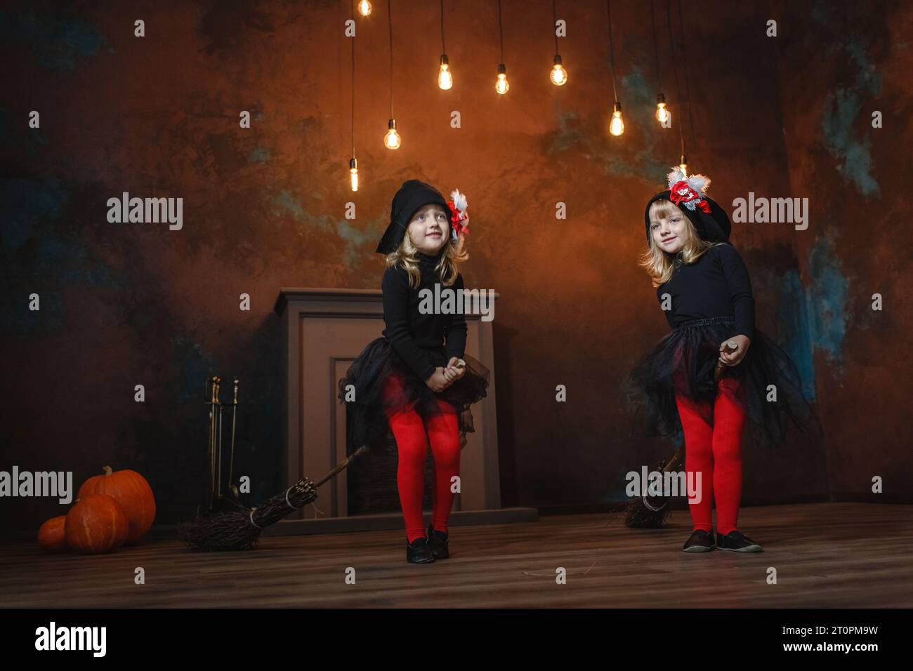 The little witches sit on their brooms, about to fly away through the ...