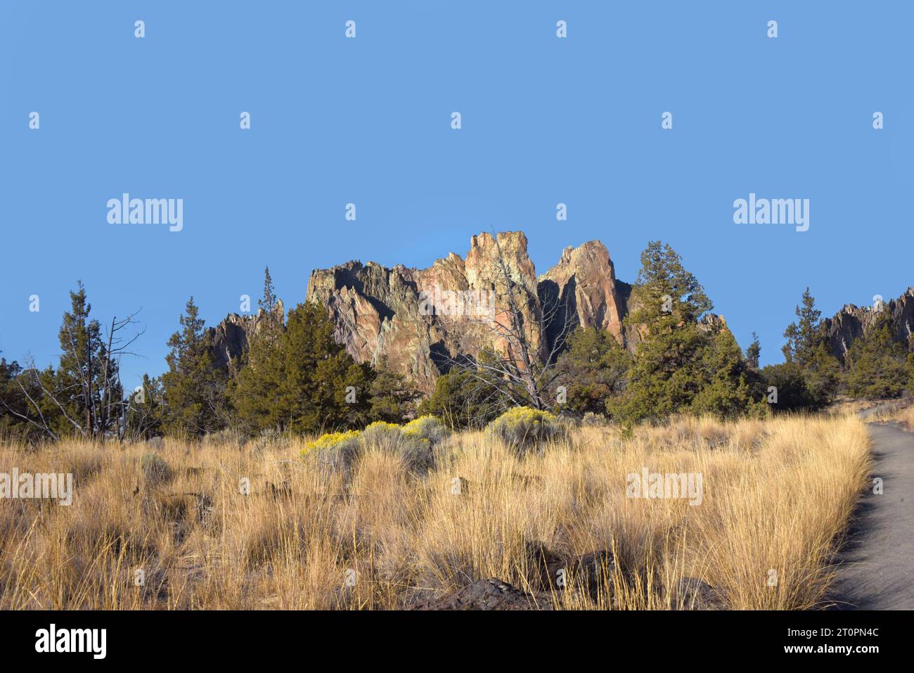 Morning sunshine illuminates the craggy and steep rocky sides of ...