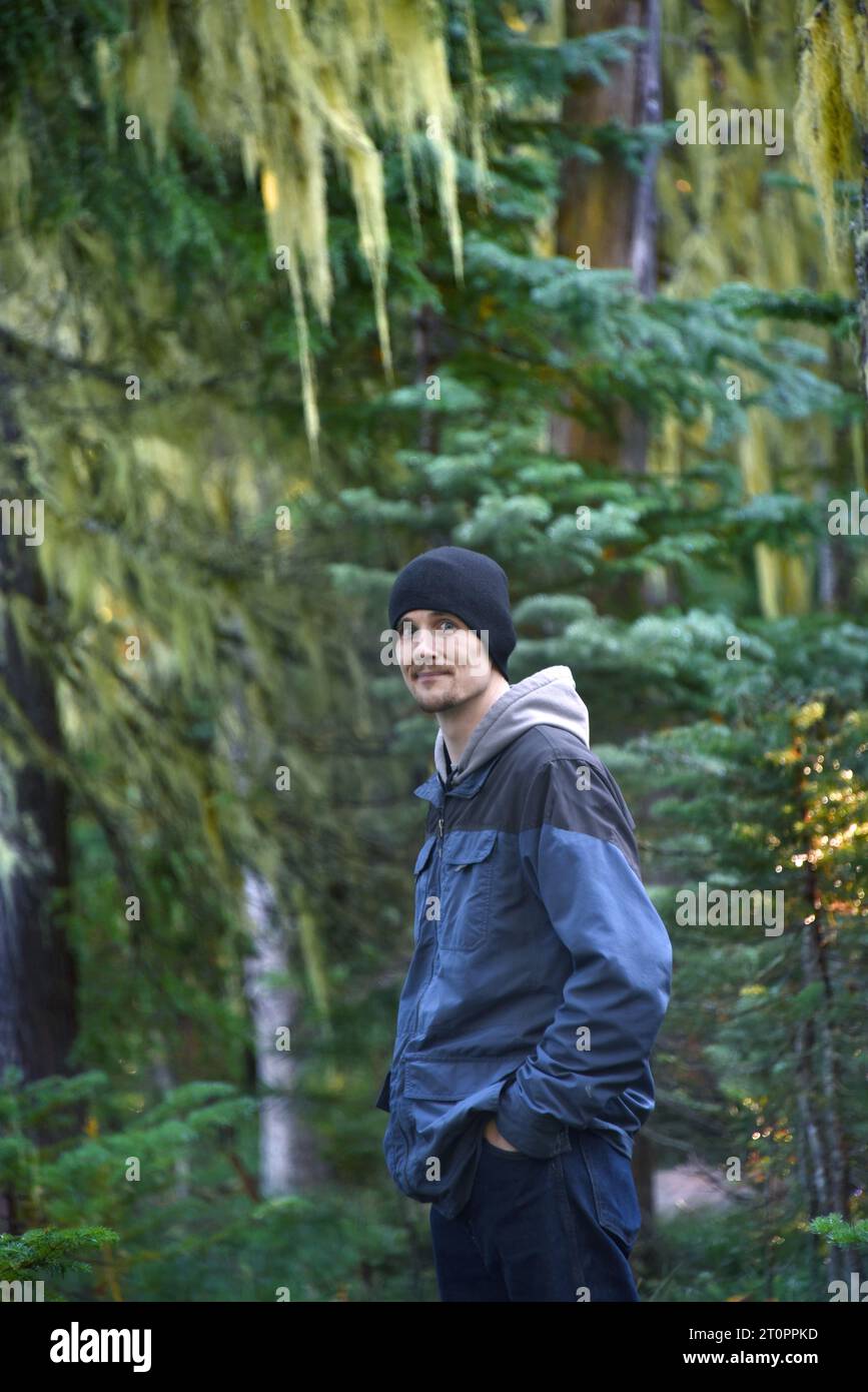 Attractive young man, stands with hands in pockets, enjoying a walk ...