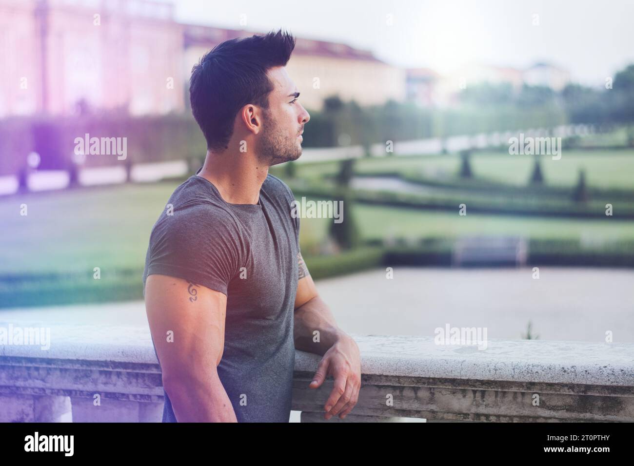 A man leaning on a wall looking off into the distance. Photo of a ...