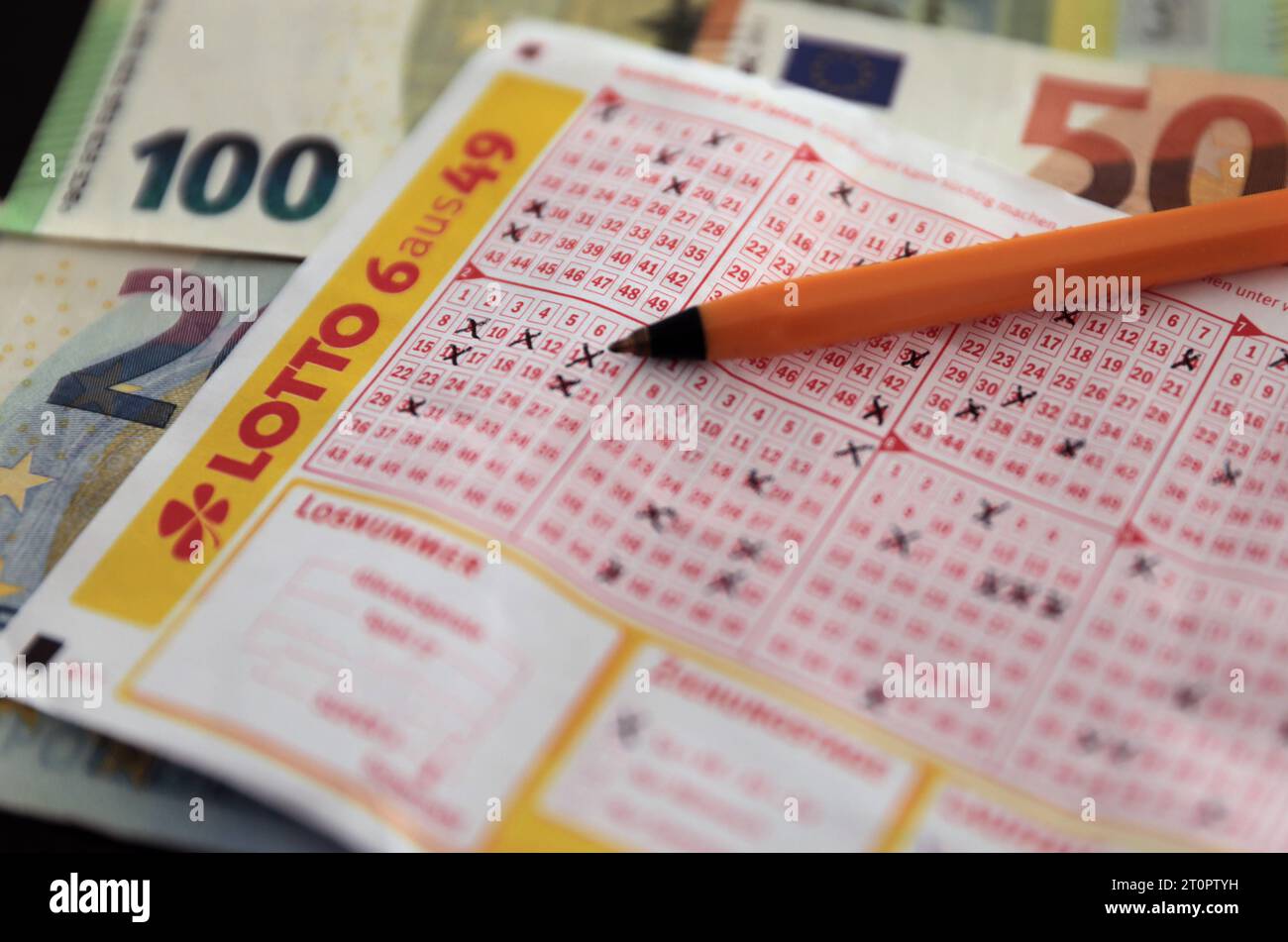 Lottoschein mit Geldnoten in Währung Euro. Symbolbild. Lottoschein mit ...