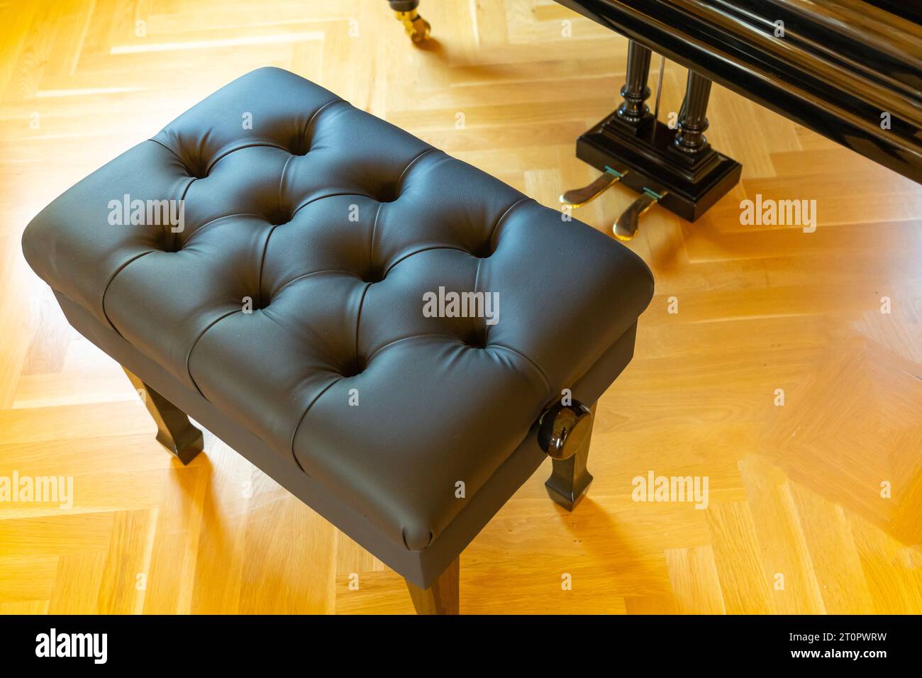 Elegant piano chair covered in black leather Stock Photo - Alamy