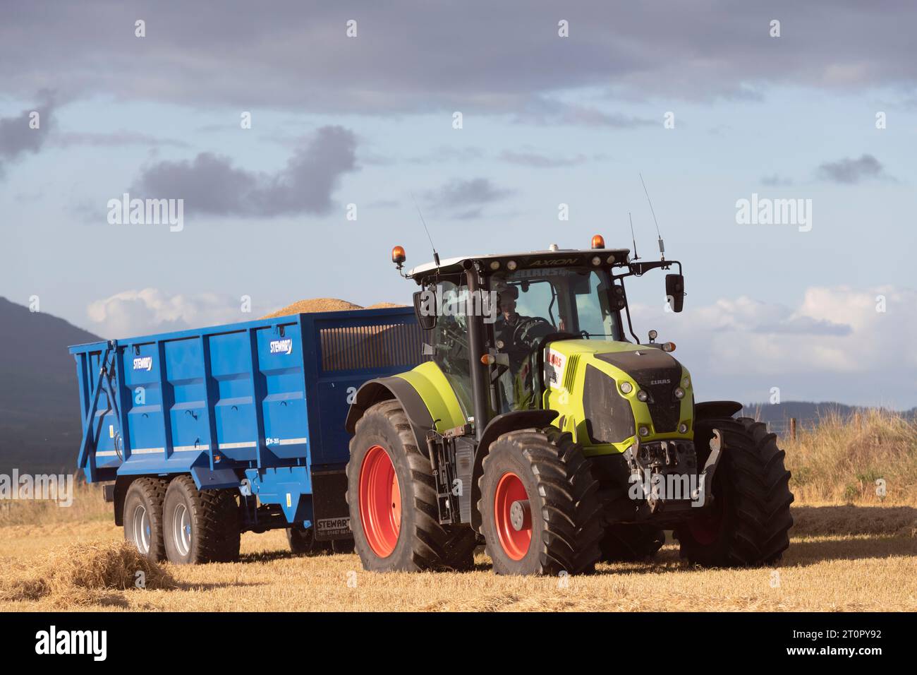 A Claas Tractor Towing a Trailer of Barley Over a Field of Stubble in ...