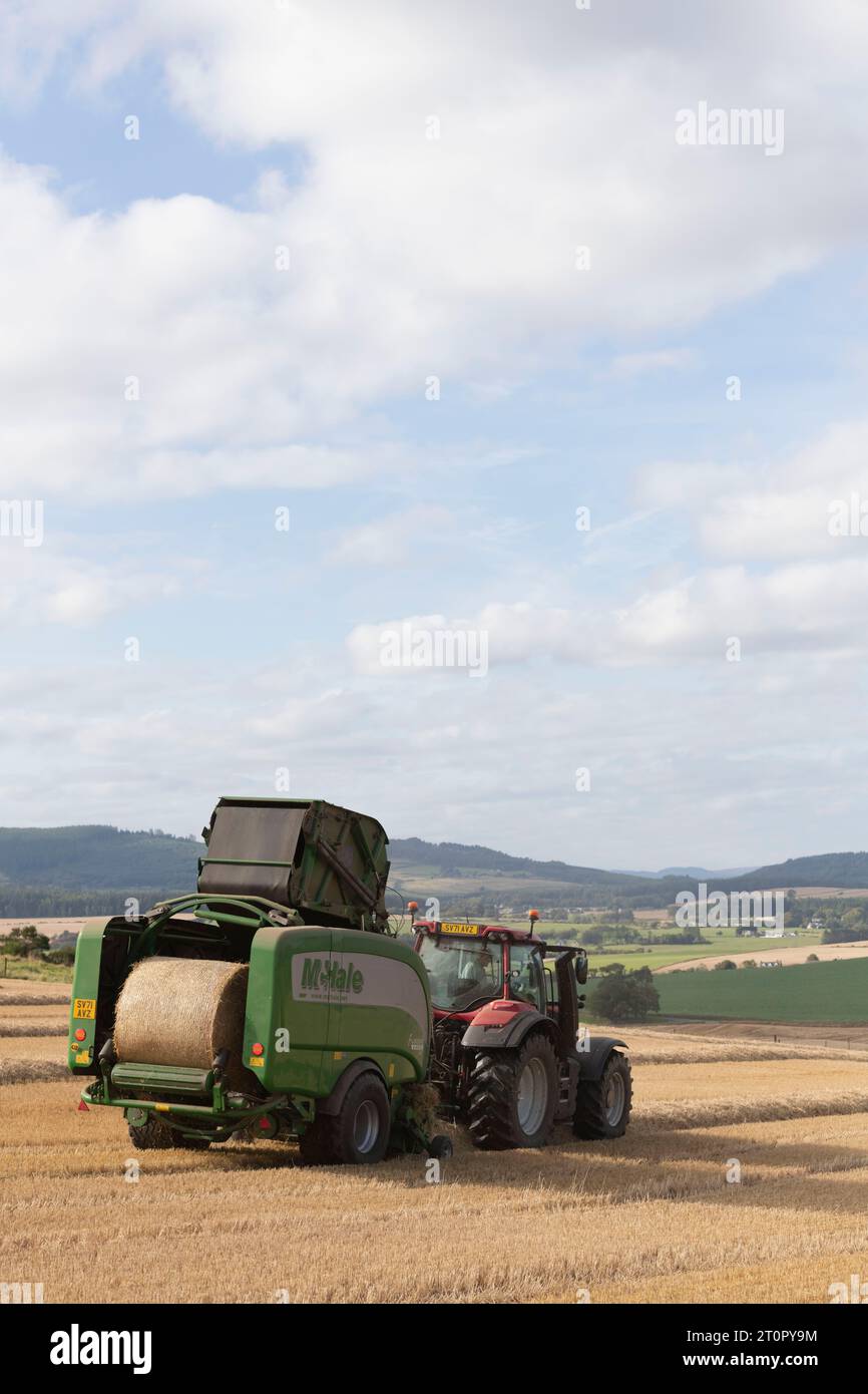 Rear View of a McHale Baler Towed by a Red Valtra Tractor Producing a ...