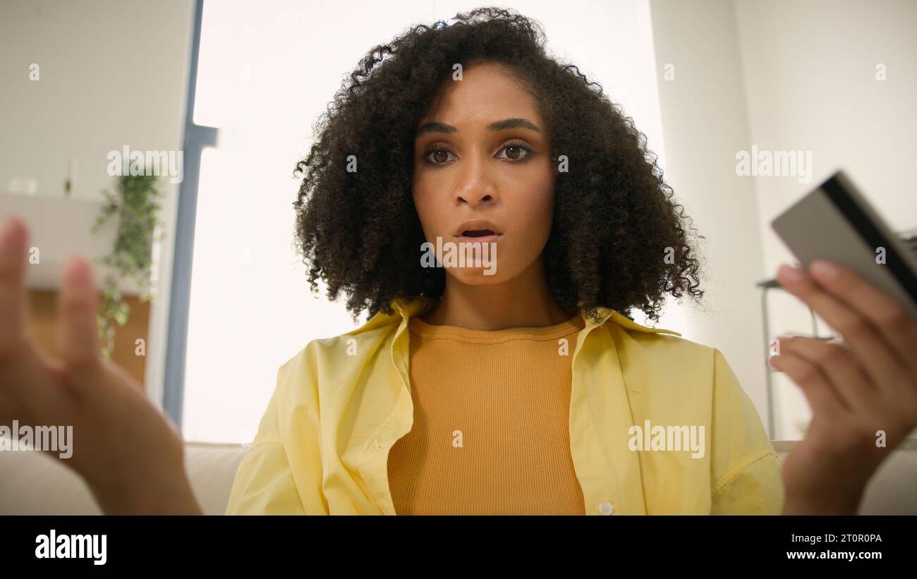POV webcam view African American woman upset stressed girl pay online with laptop and credit ...