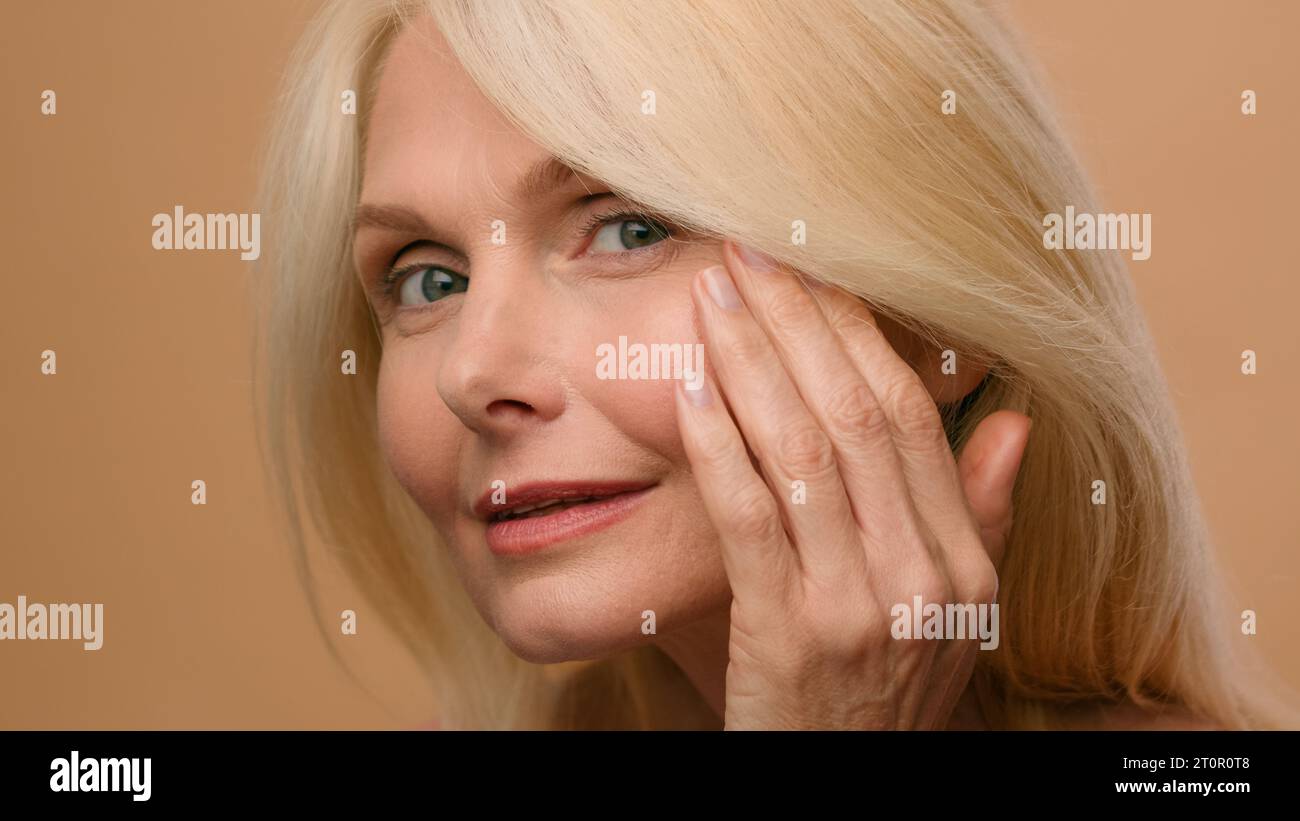 Close up mature elderly woman 50s model with pipette dripping serum ...