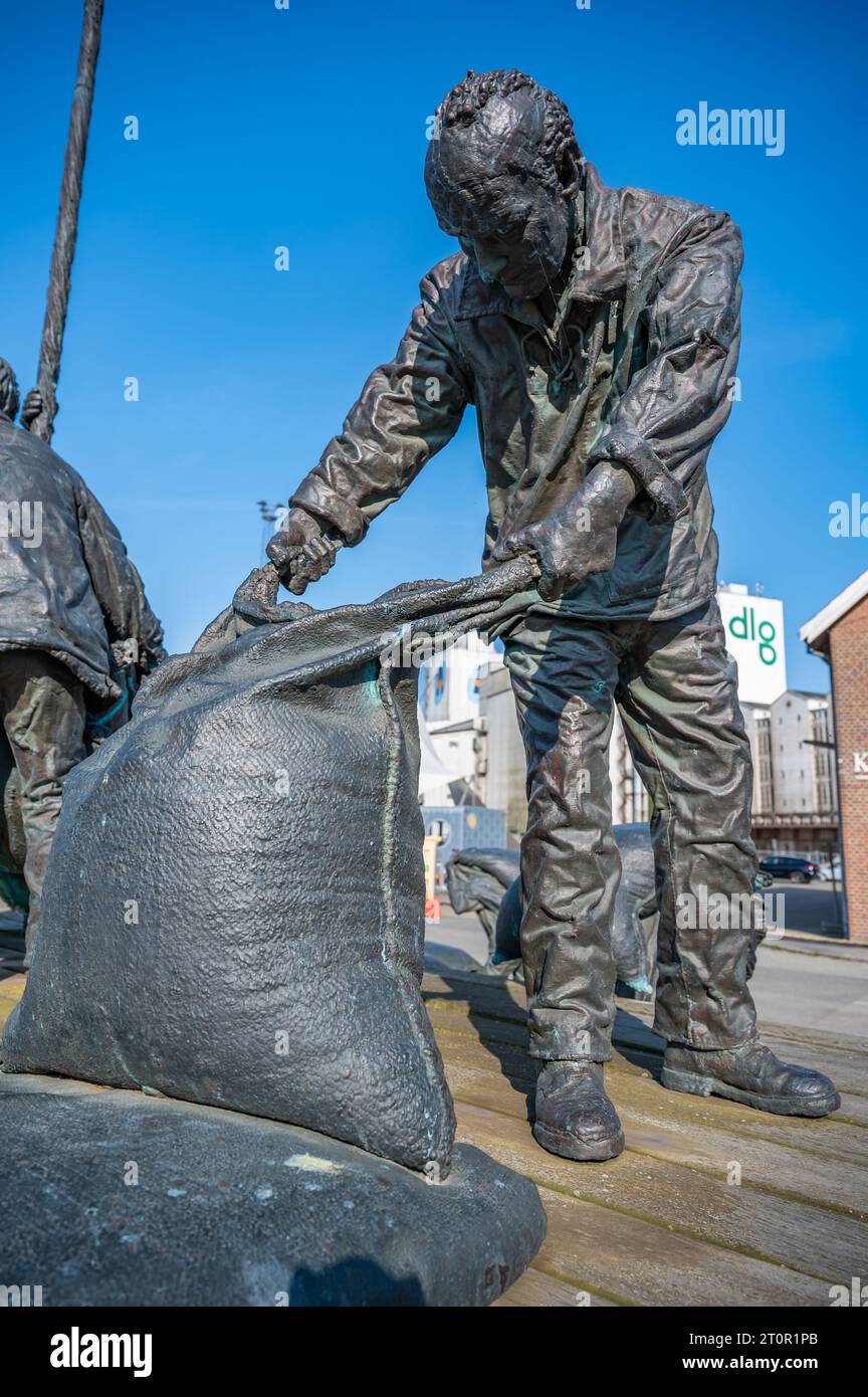 Statue monument of a man putting a bag don on the ground at the Port ...