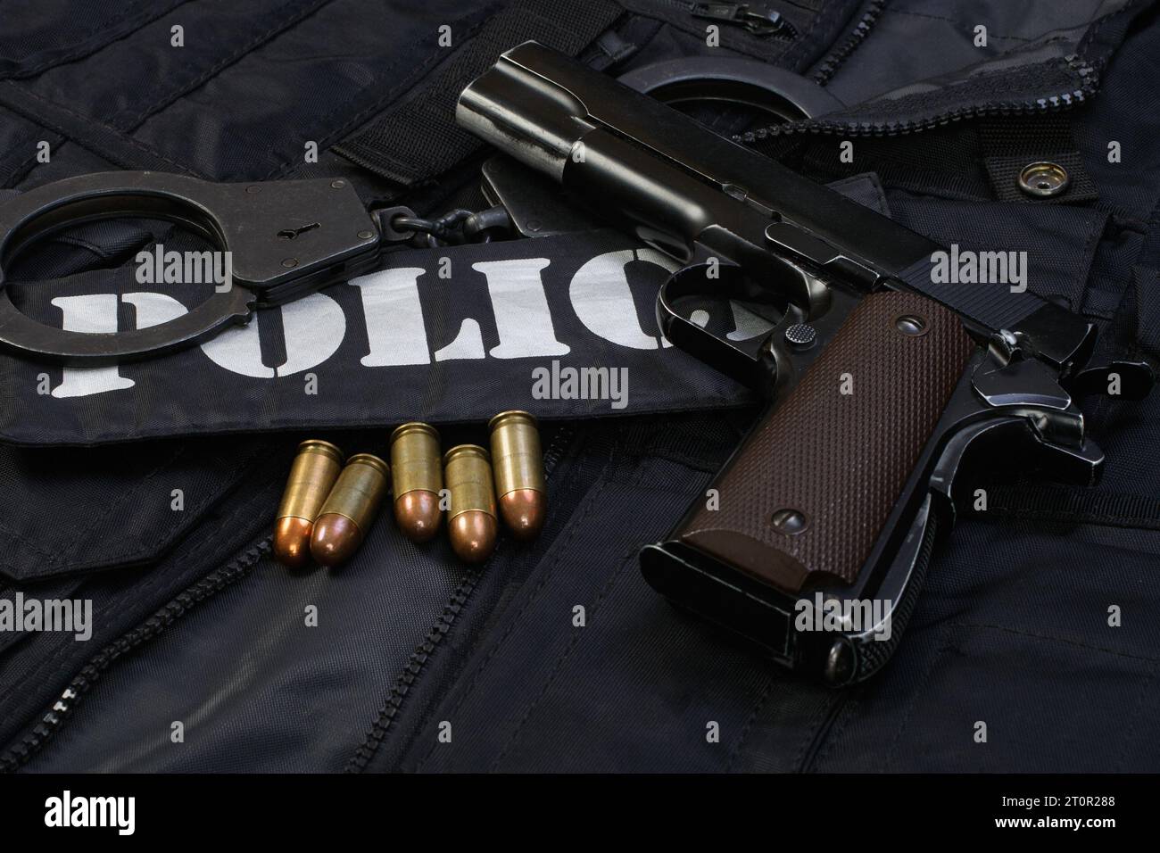 Police handgun with handcuffs on black uniform background Stock Photo ...