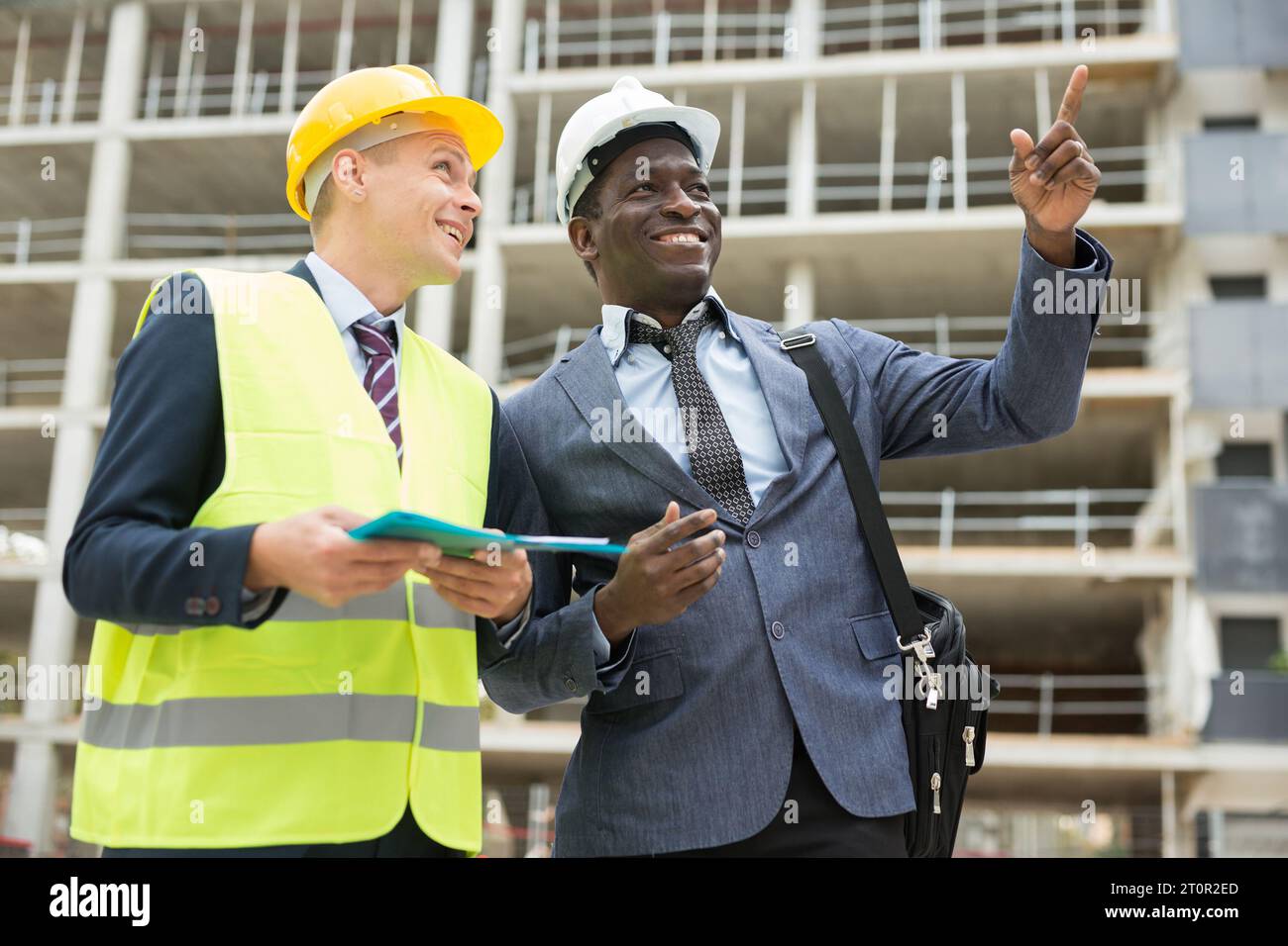 African-american architect discusses a construction plan with an ...