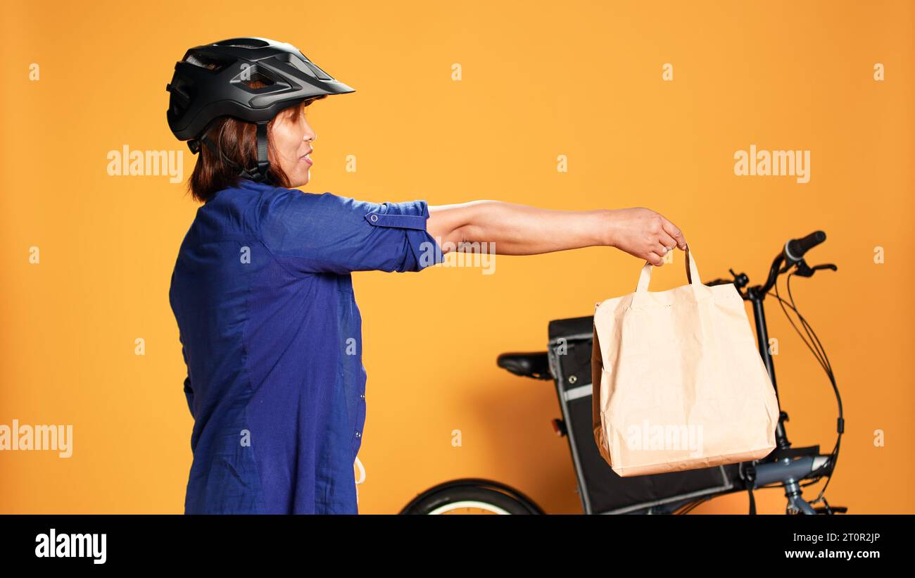 BIPOC food delivery worker reaching order address, waiting for customer ...