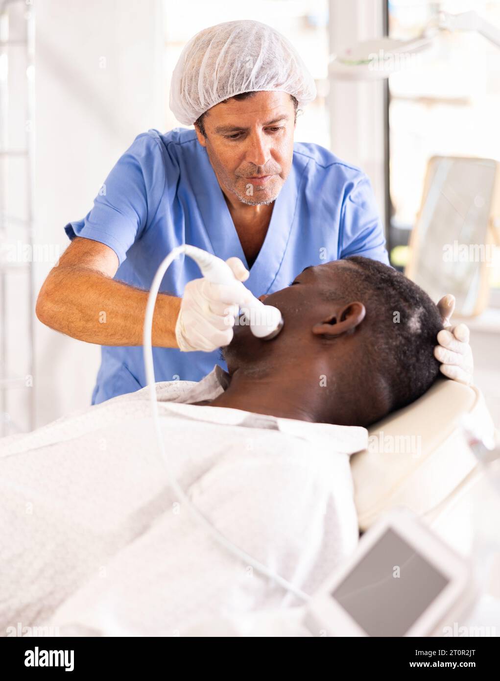 Professional aesthetician administering high frequency ultrasound ... Professional aesthetician administering high frequency ultrasound ...