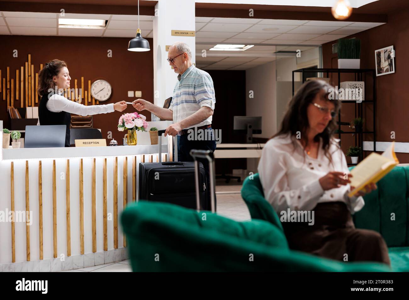 After completing registration at hotel lobby front desk, caucasian ...