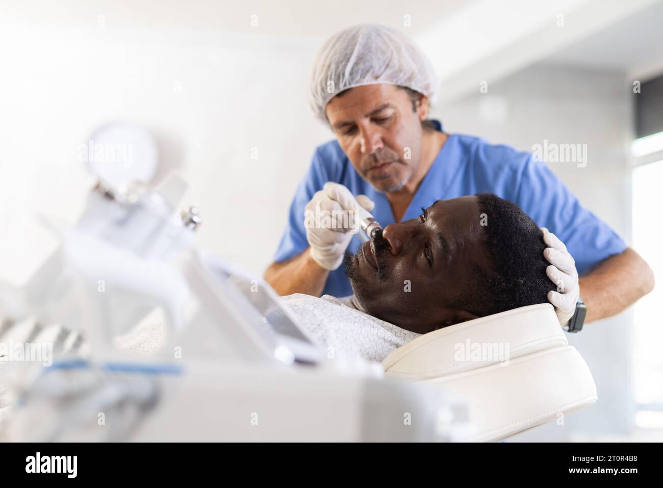 Male cosmetologist performs skin cleansing procedure for African man ...