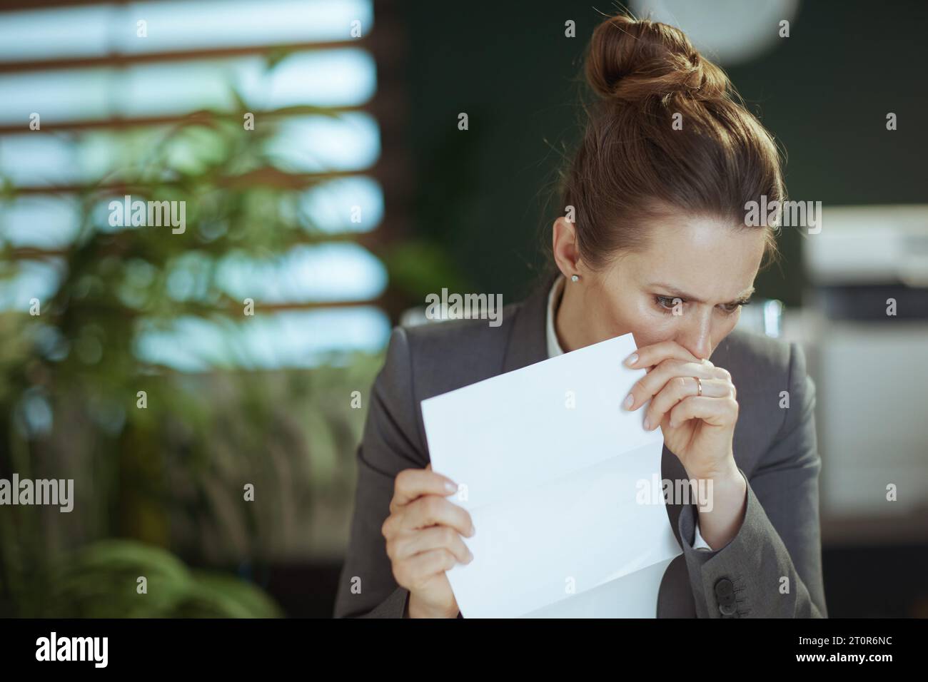 New job. sad modern middle aged woman employee in modern green office ...