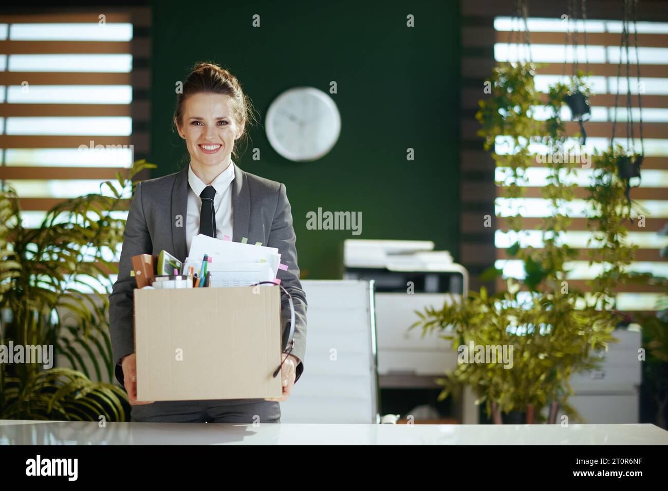New job. happy modern female worker in modern green office in grey ...