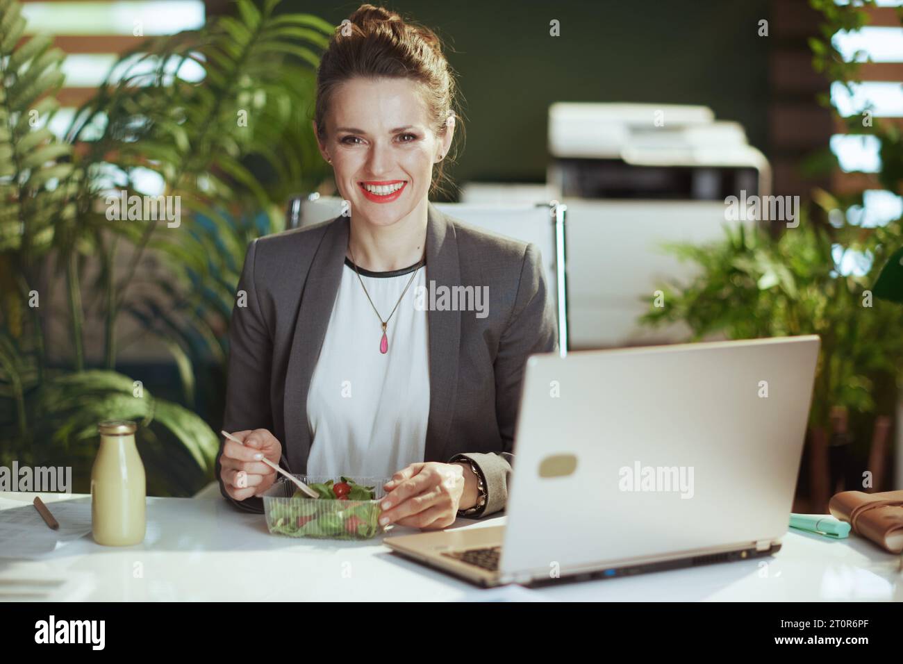 Sustainable workplace. smiling modern accountant woman in a grey ...