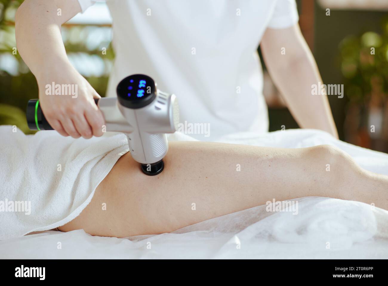 Healthcare time. Closeup on medical massage therapist in massage cabinet with massage pistol ...