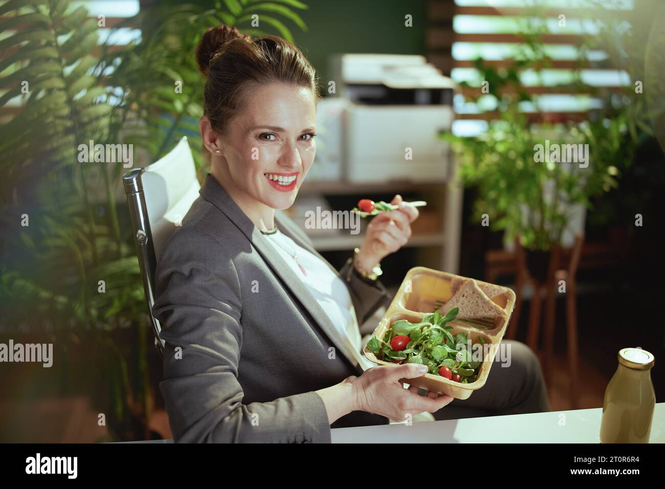 Sustainable workplace. happy modern woman worker in a grey business ...