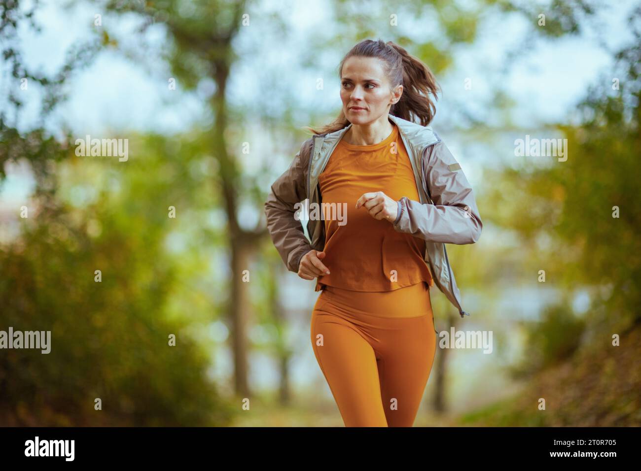 Hello autumn. fit woman in fitness clothes in the park running Stock ...