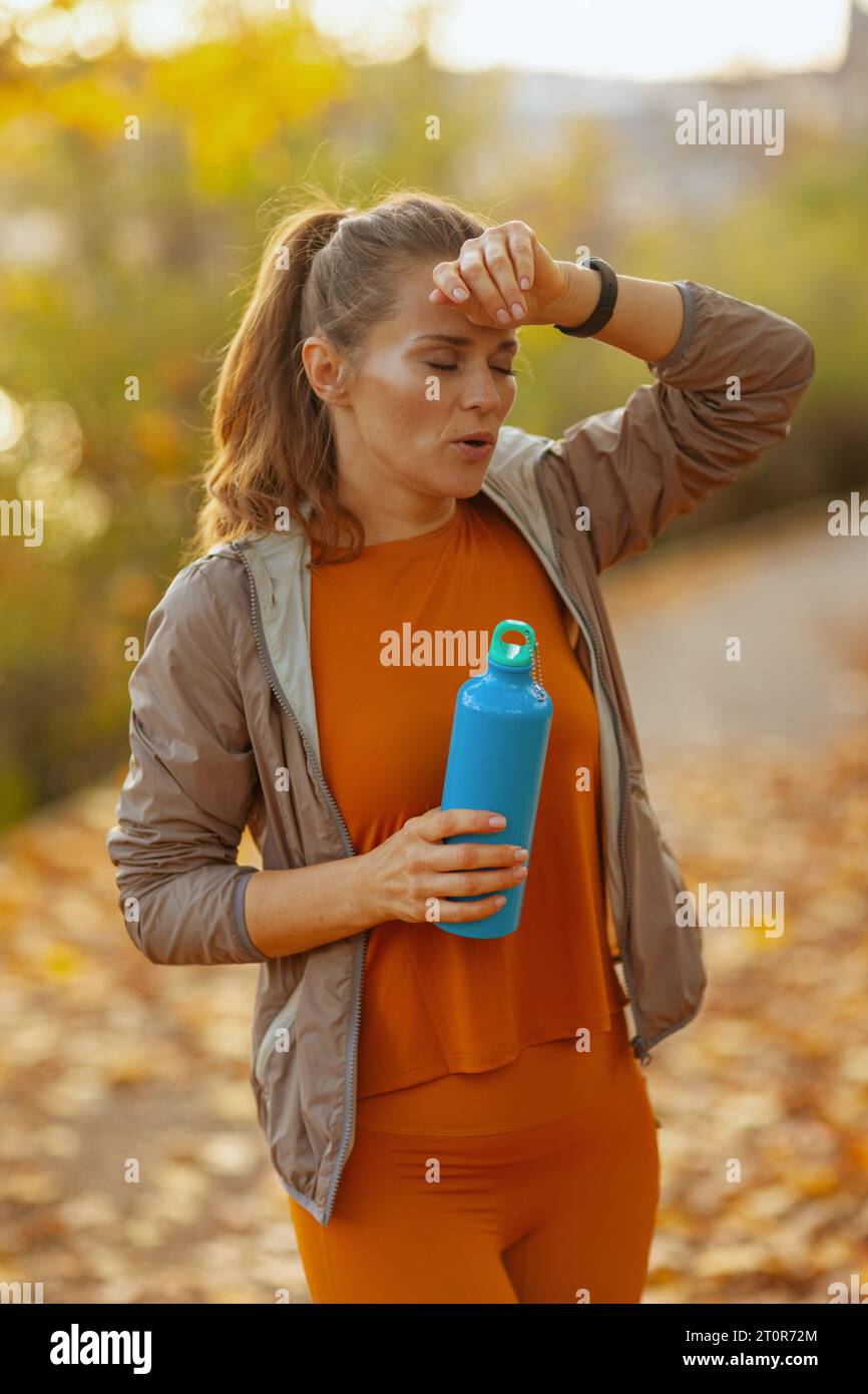 Hello autumn. tired trendy woman in fitness clothes in the park with ...