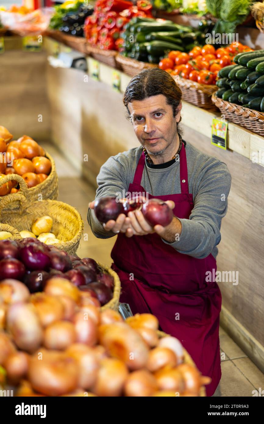 Adult man selling onions in shop Stock Photo - Alamy