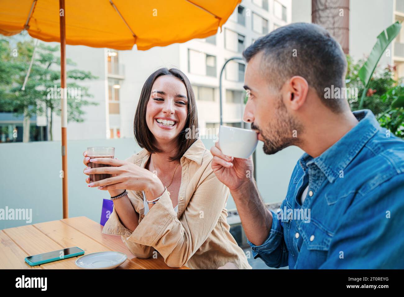 Happy caucasian young couple taking a break after shopping on a coffee ...