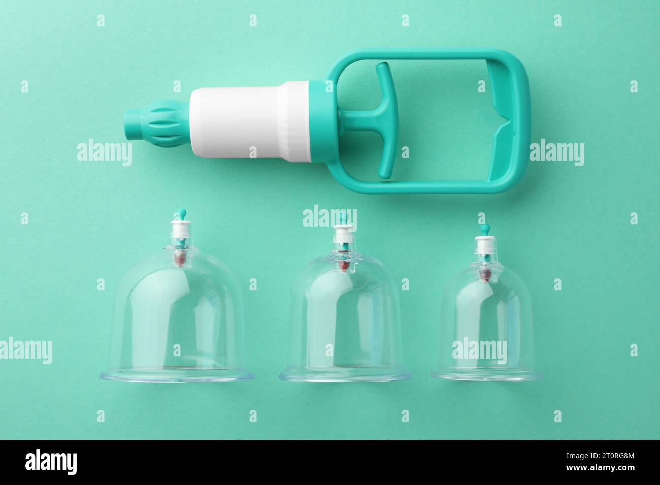 Plastic cups and hand pump on turquoise background, flat lay. Cupping ...
