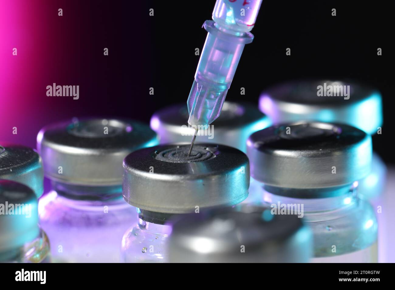 Filling syringe with medicine from vial on color background, closeup ...