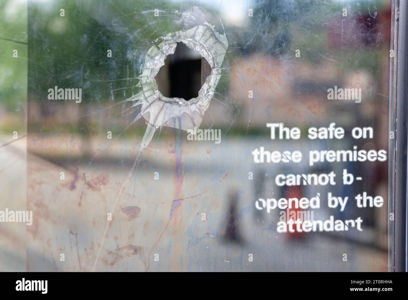 bullet proof glass window at a shop with a bullet hole in it ...
