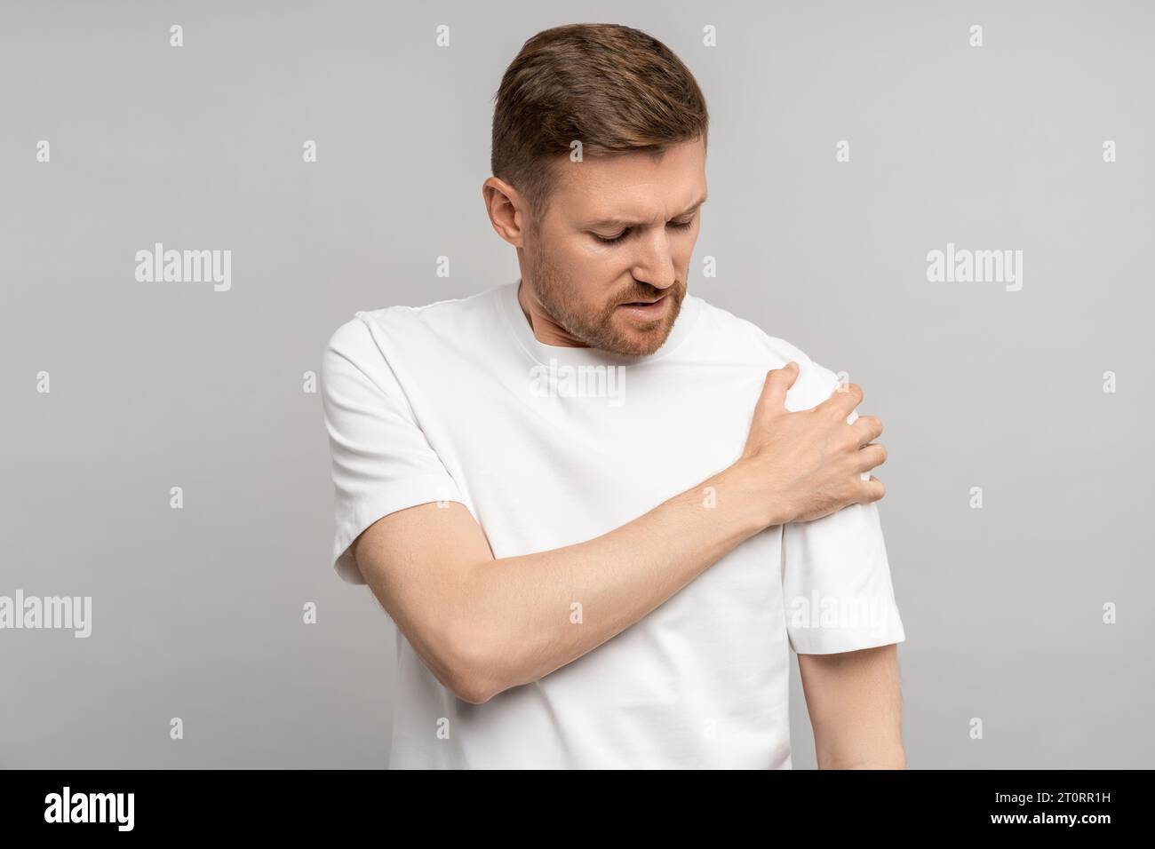 Unhealthy man holds on to sore shoulder. Guy experiences throb pain in ...