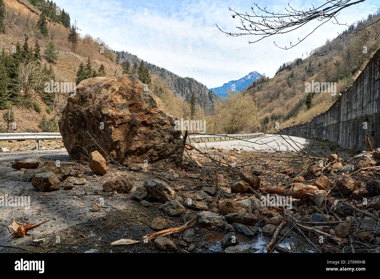 A huge rock fell from the mountains onto the road, destroying the ...