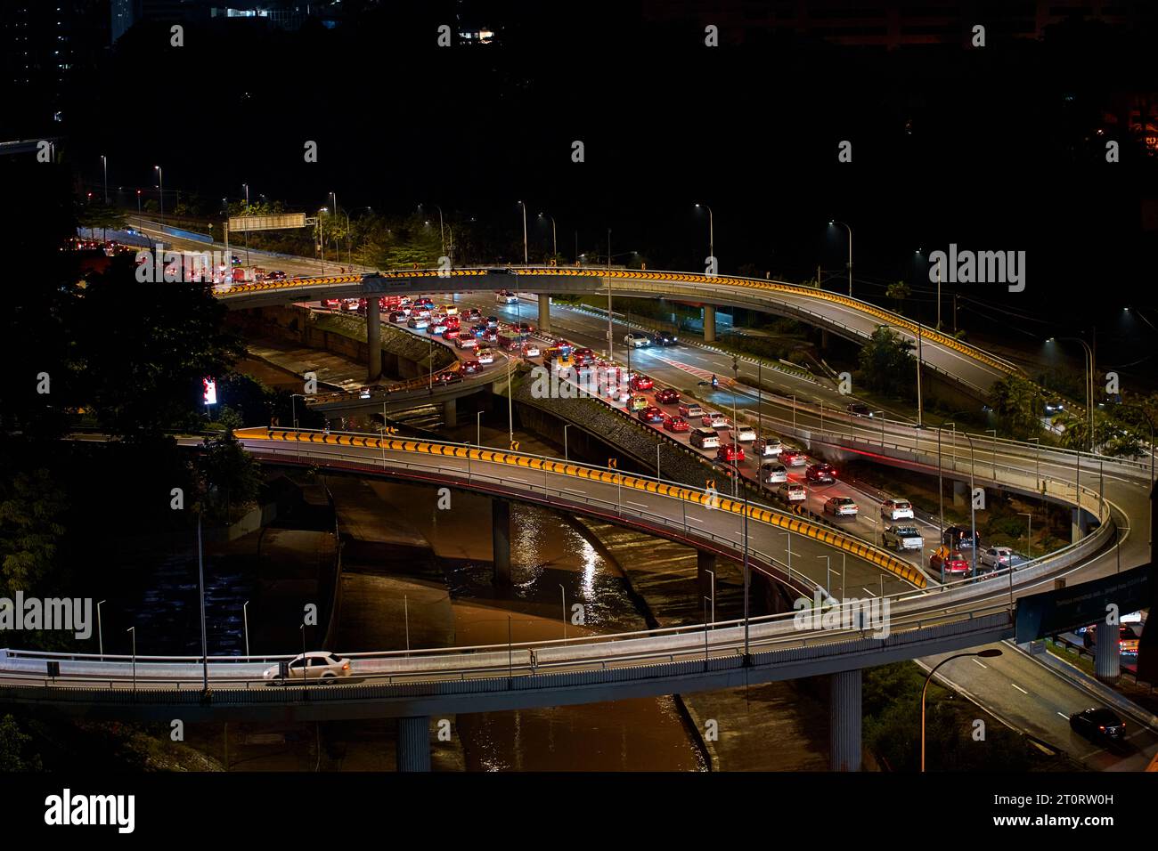 Night photo of a glowing multi-level road junction with heavy traffic ...