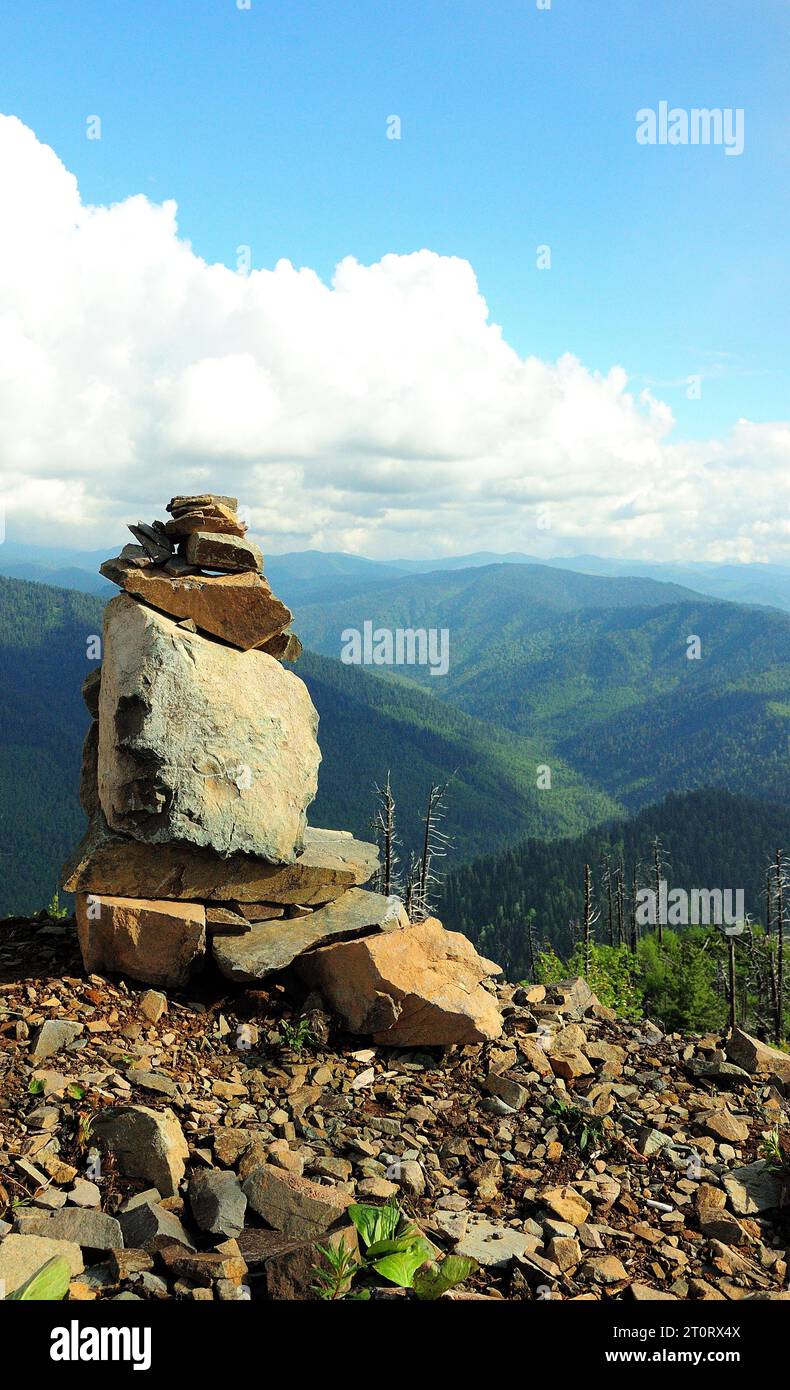 Ritual stone pyramid on top of a mountain overlooking high hills under ...