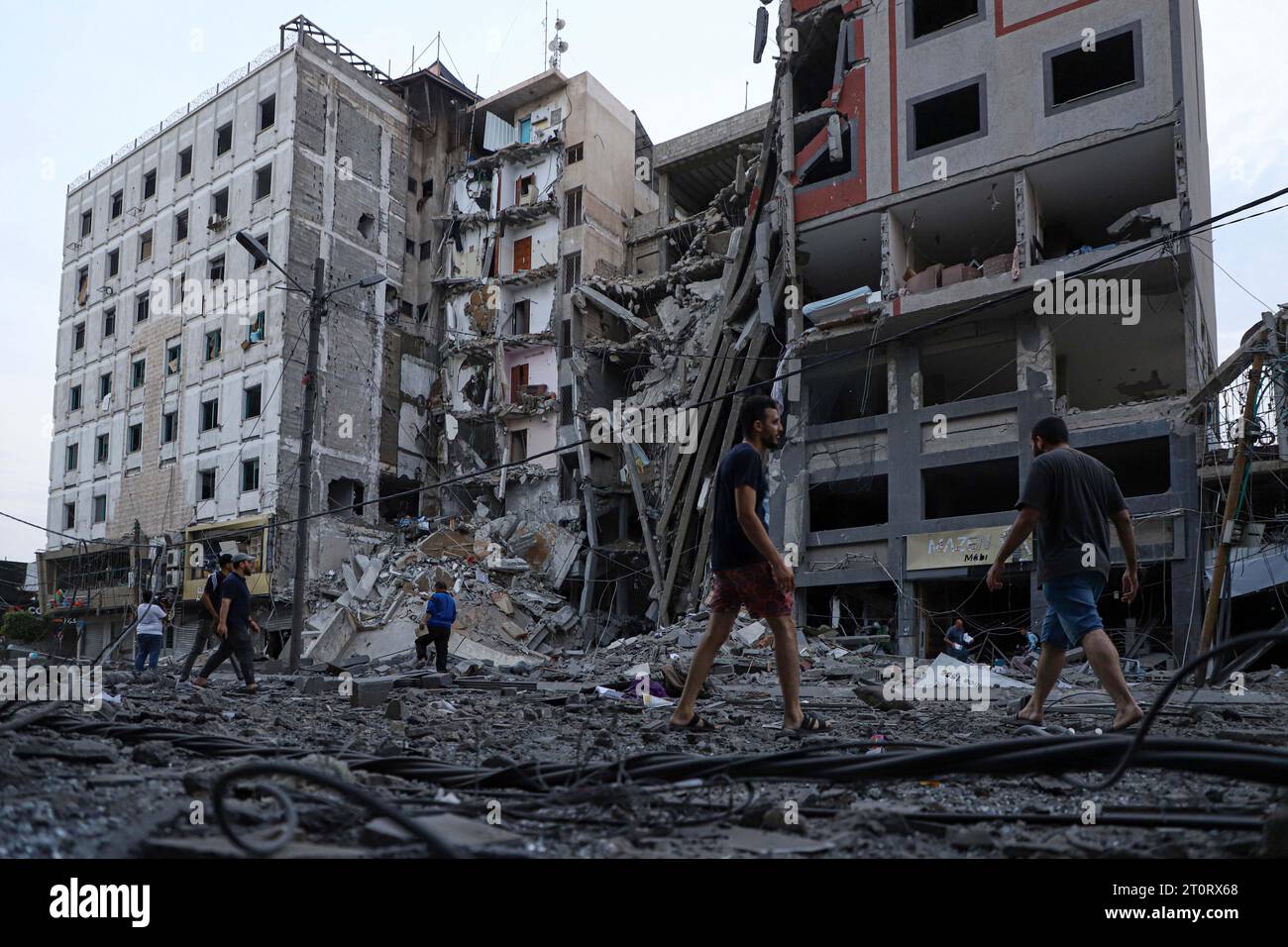 Gaza. 8th Oct, 2023. Palestinians check destroyed buildings following ...