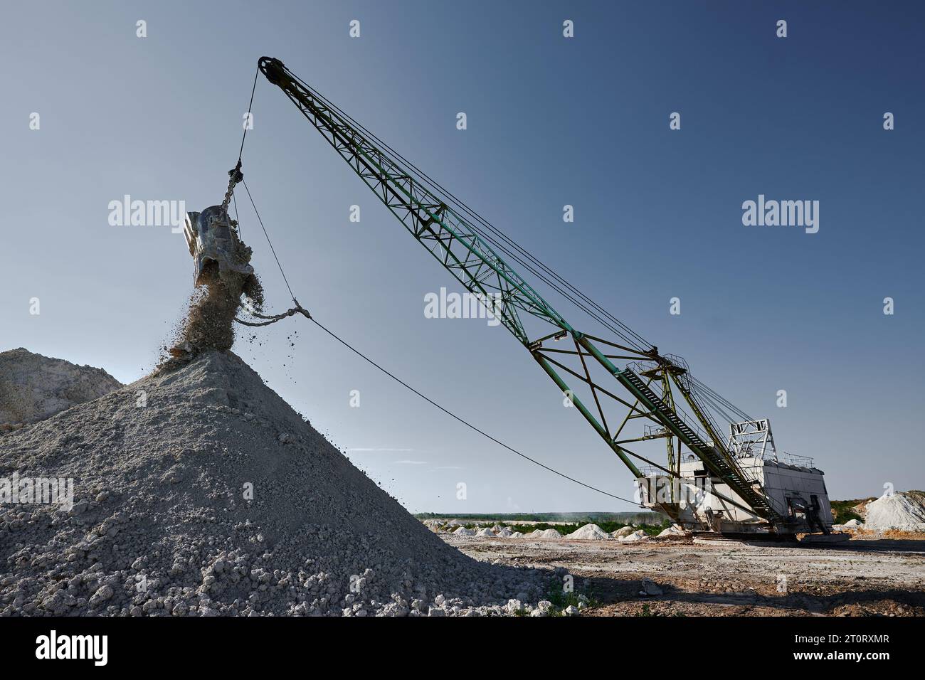 Dragline pours chalk from bucket operating in open quarry Stock Photo ...
