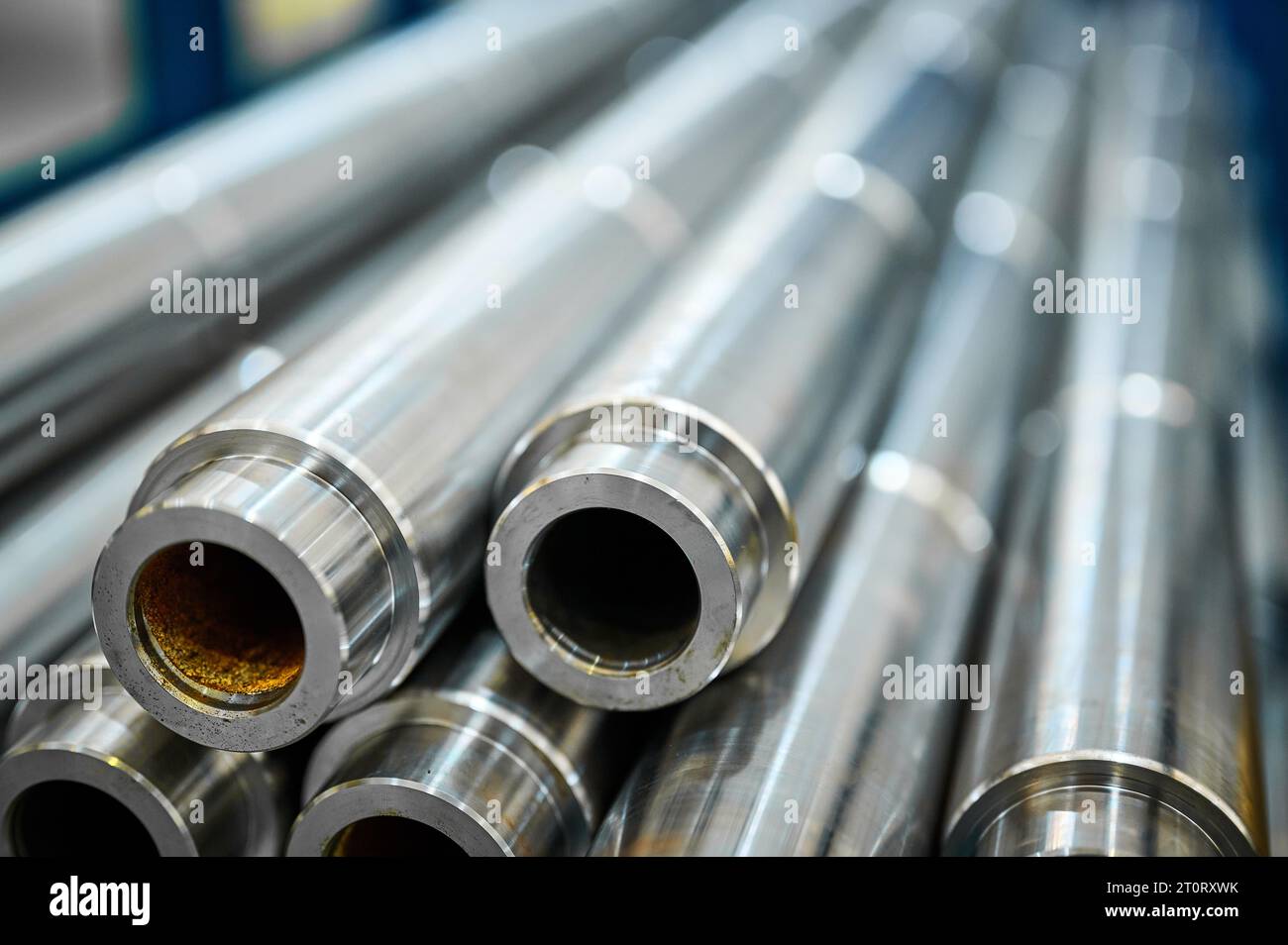 Pile of long drill rods metal workpieces in light warehouse Stock Photo ...
