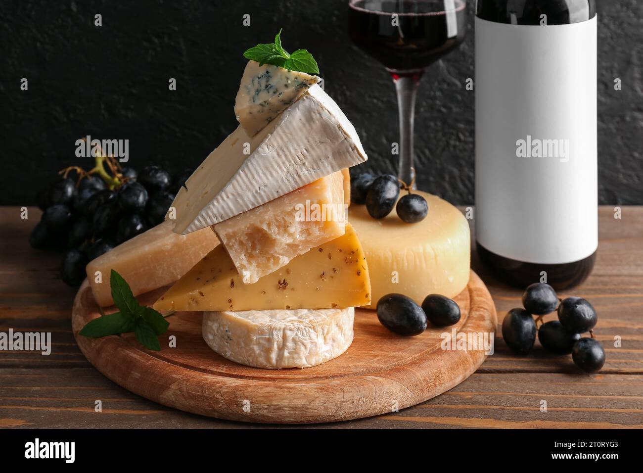 Wooden board with different types of tasty cheese on table Stock Photo ...