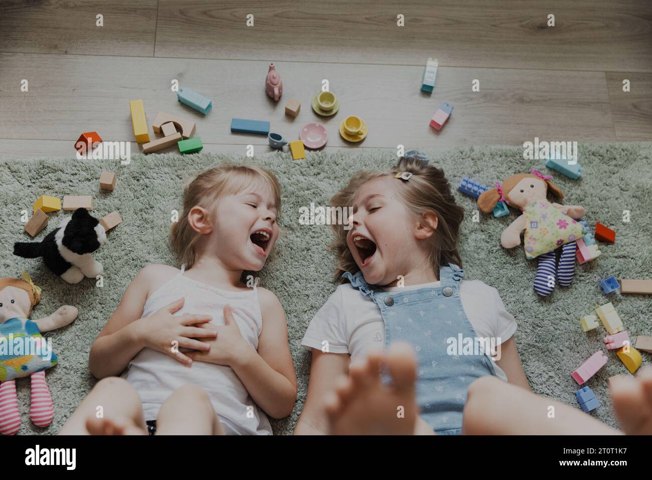 Top view from above on children playing with colorful toys. Portrait of ...