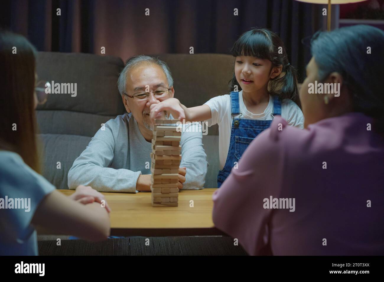 Asian family enjoy playing toy block with little daughter together in home living room Stock ...